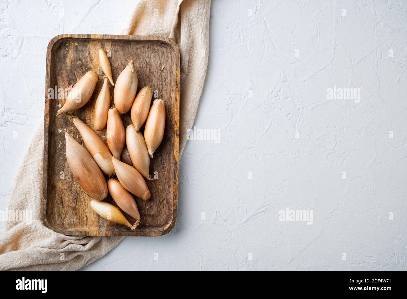 Raw whole baby shallot onion, on white textured background, flat lay ...