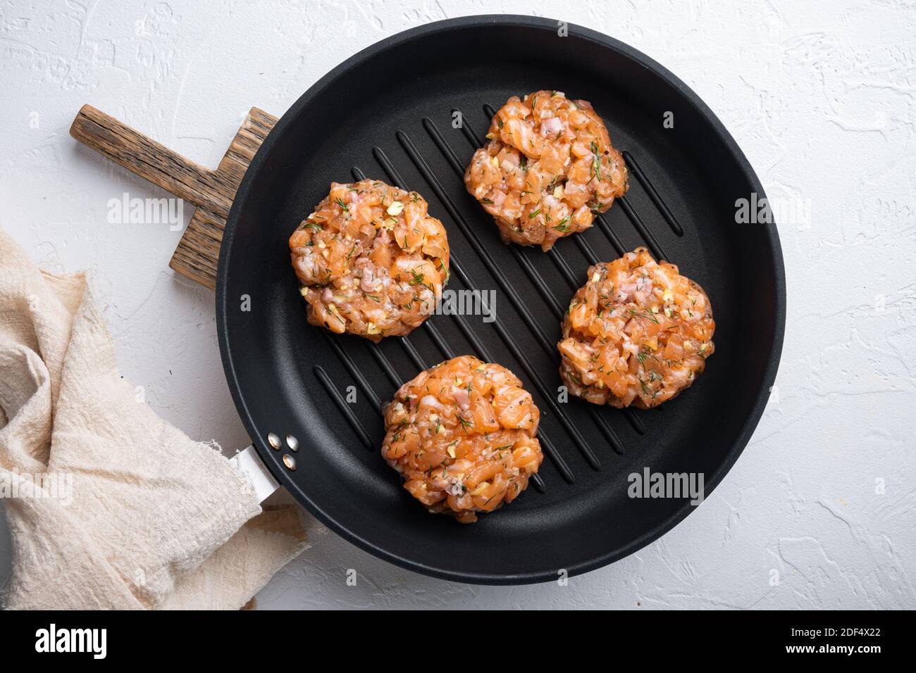 Quick asian raw fish patties with herb, on white textured background ...