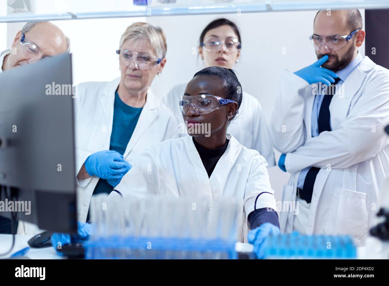 Multiethnic group of laboratory scientists discussing their research in ...