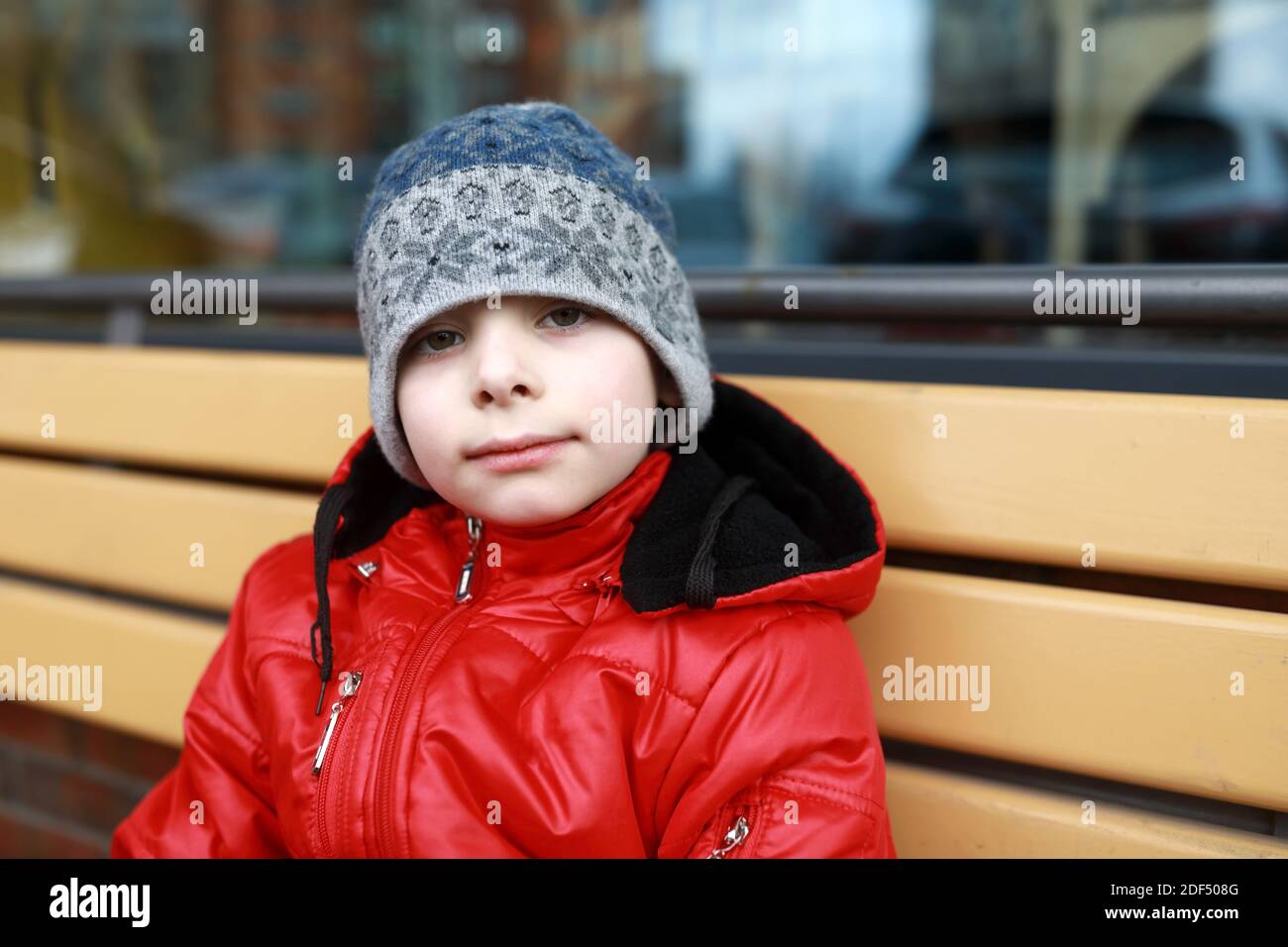 Portrait of boy sitting on bench in spring Stock Photo - Alamy