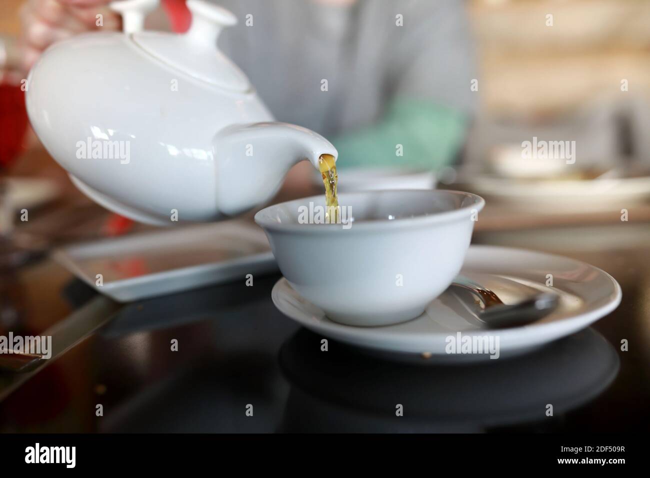 Person pouring tea from kettle hi-res stock photography and images - Alamy