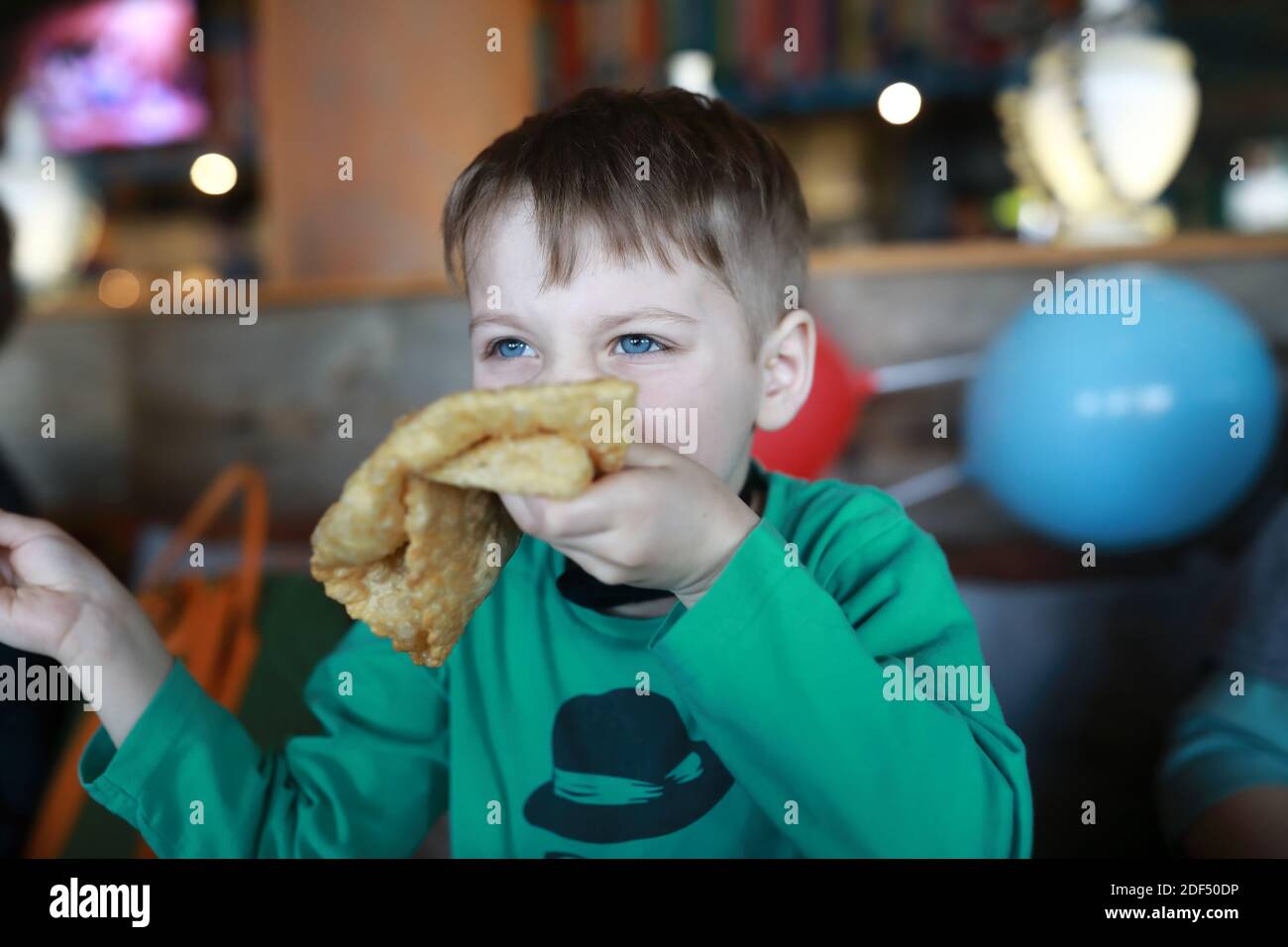 Child eating cheburek in an asian restaurant Stock Photo - Alamy