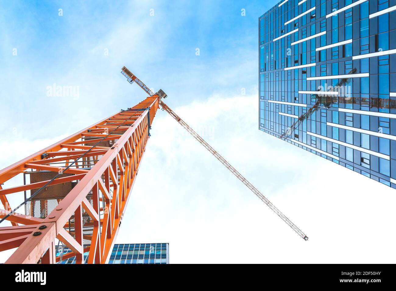 Yellow tower crane. Bottom view of a tall construction crane next to a ...