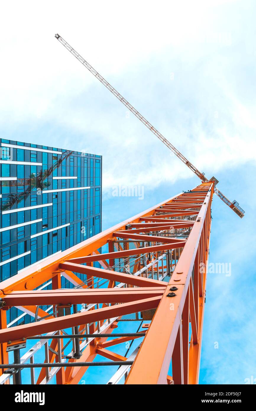 Yellow tower crane. Bottom view of a tall construction crane next to a ...