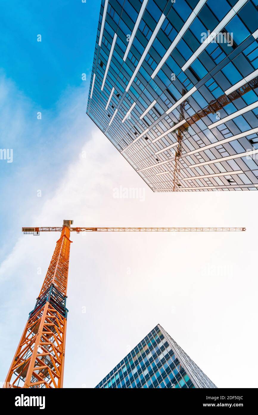 Yellow tower crane. Bottom view of a tall construction crane next to a ...