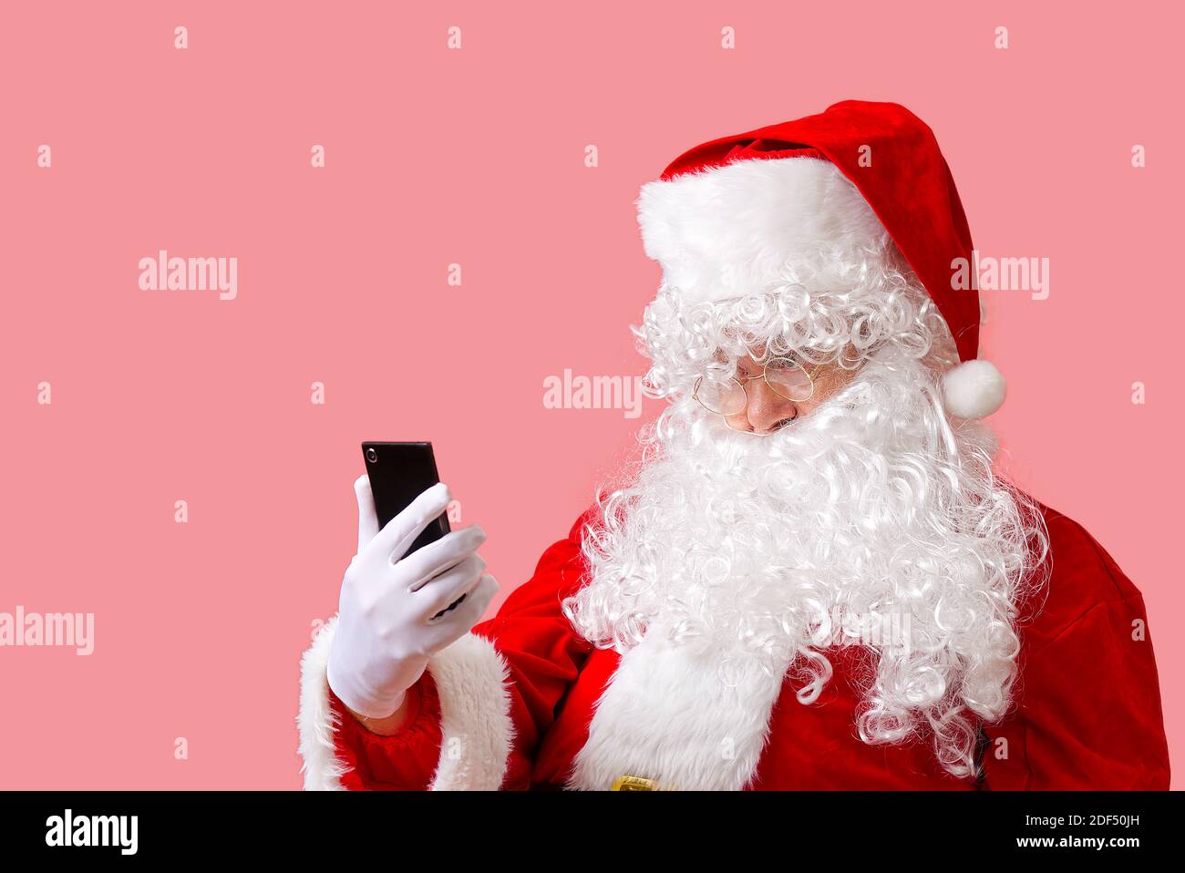 santa claus with mobile phone isolated on pink background Stock Photo ...