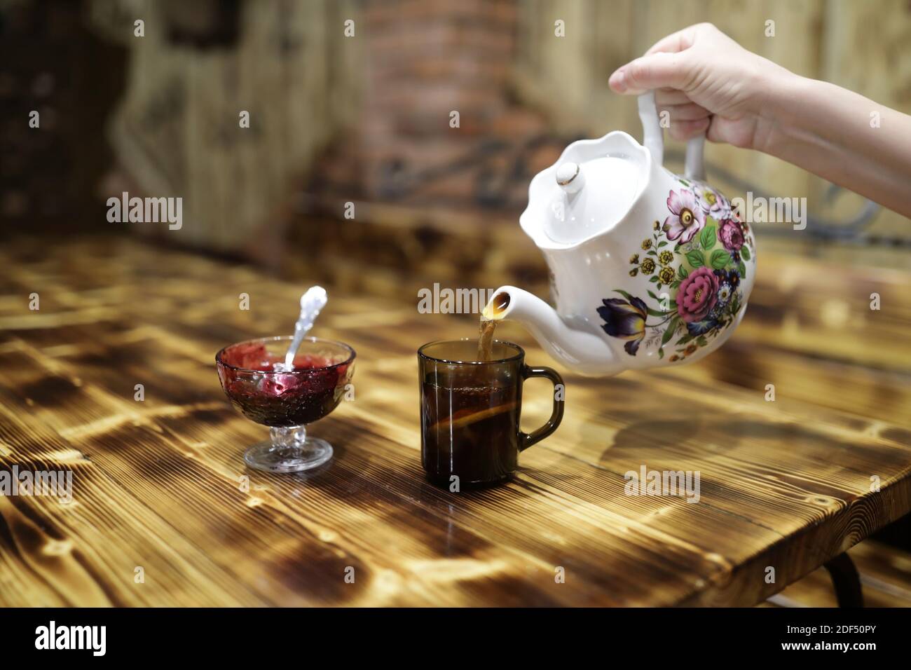 Person pouring tea from teapot in restaurant Stock Photo - Alamy