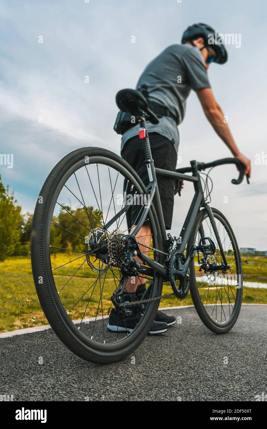 Vertical shot of cyclist with a road bike on the asphalt bicycle path ...