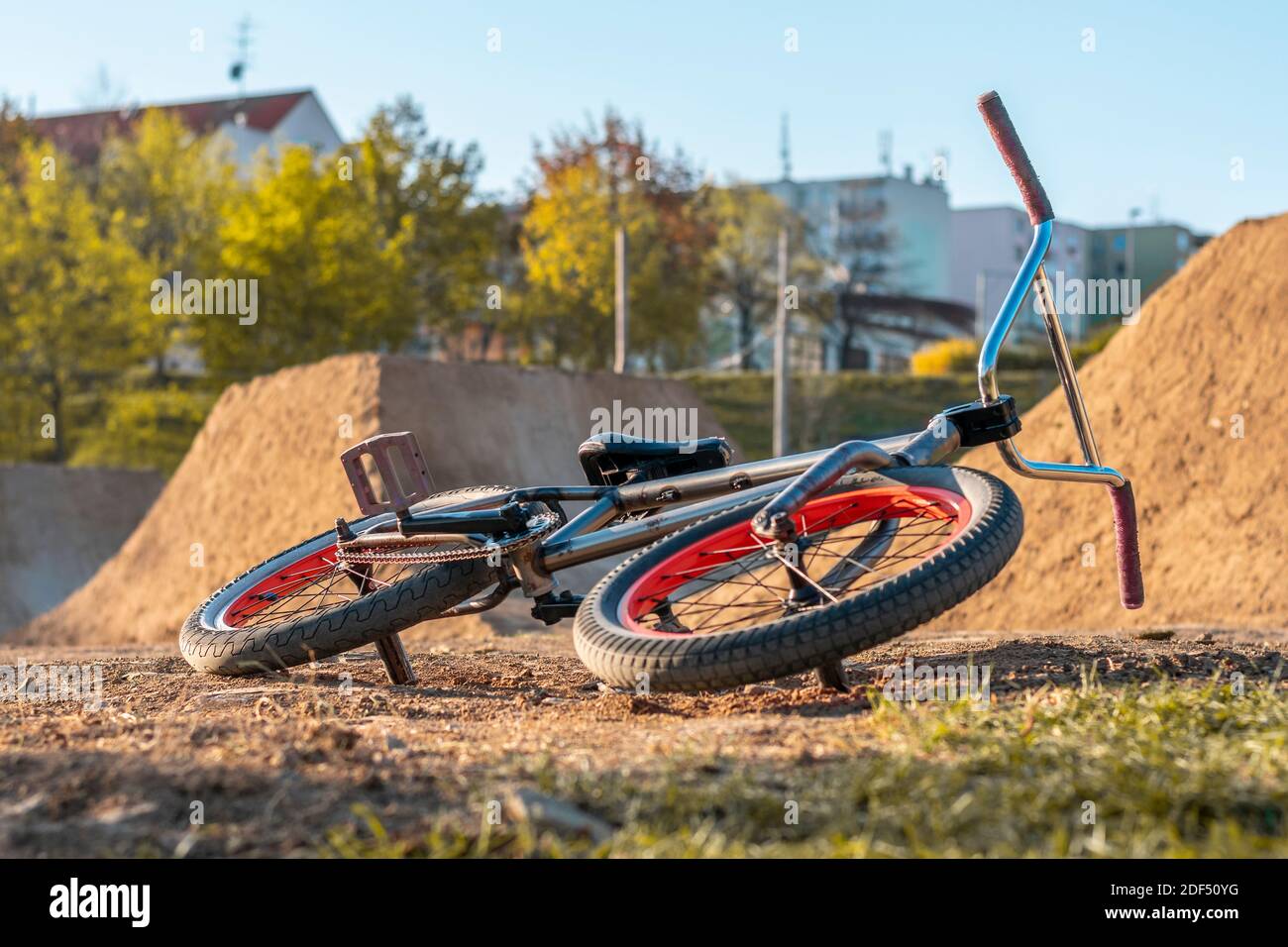 BMX bike on the track with jumps on the background with houses. Jumping ...