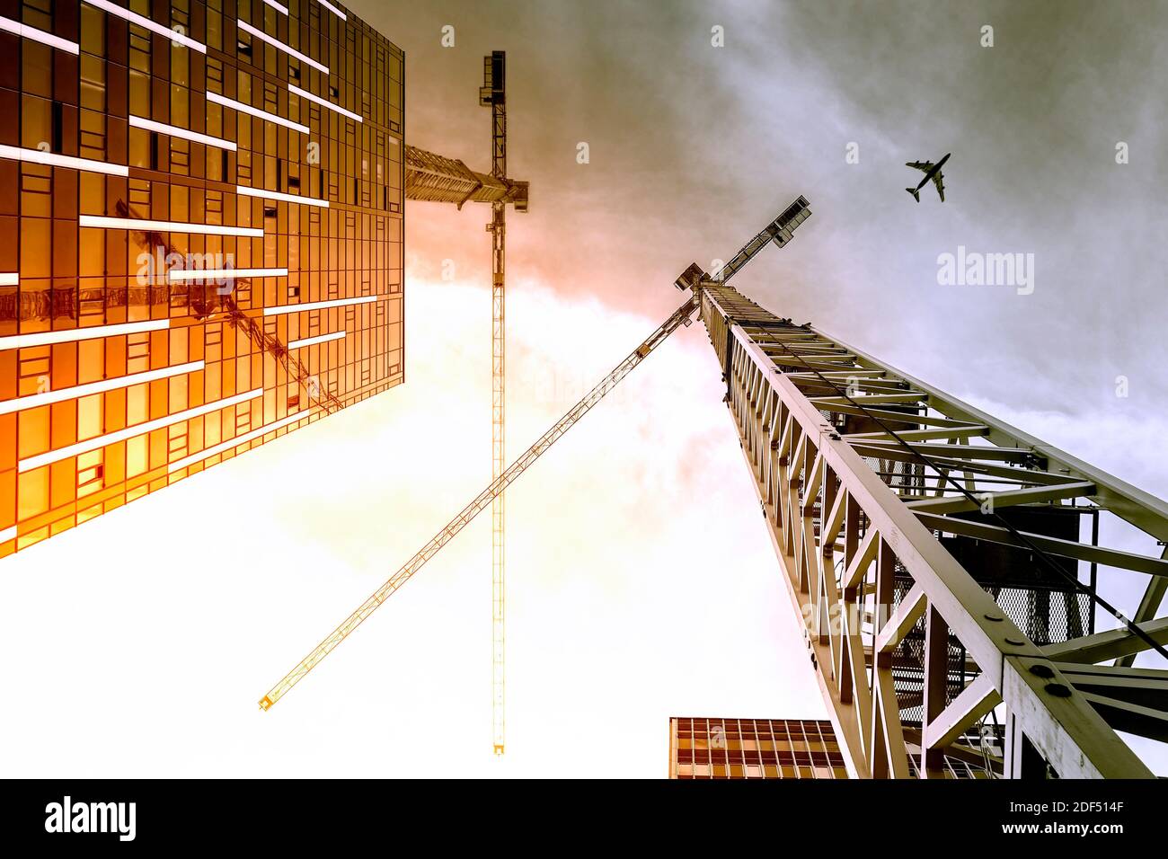 Tower crane. Bottom view of a tall construction cranes next to a modern ...