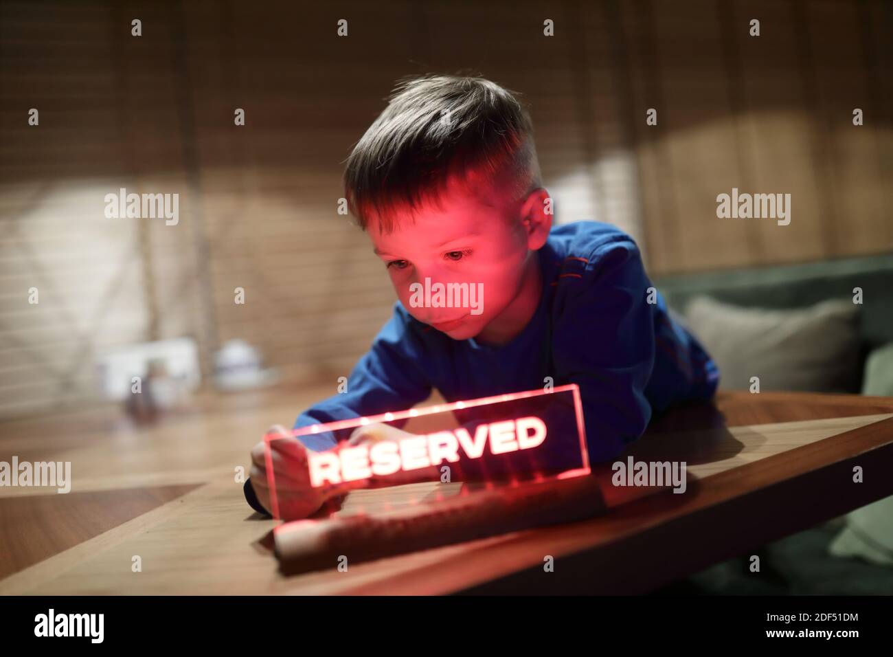 Child with red sign reserved in restaurant Stock Photo - Alamy