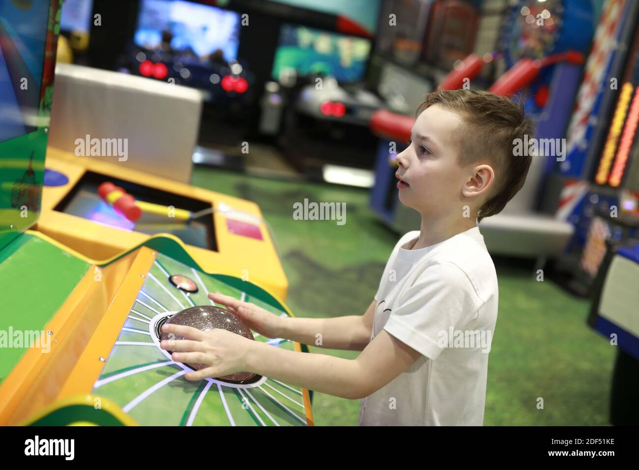 Child plays arcade game in indoor amusement park Stock Photo - Alamy