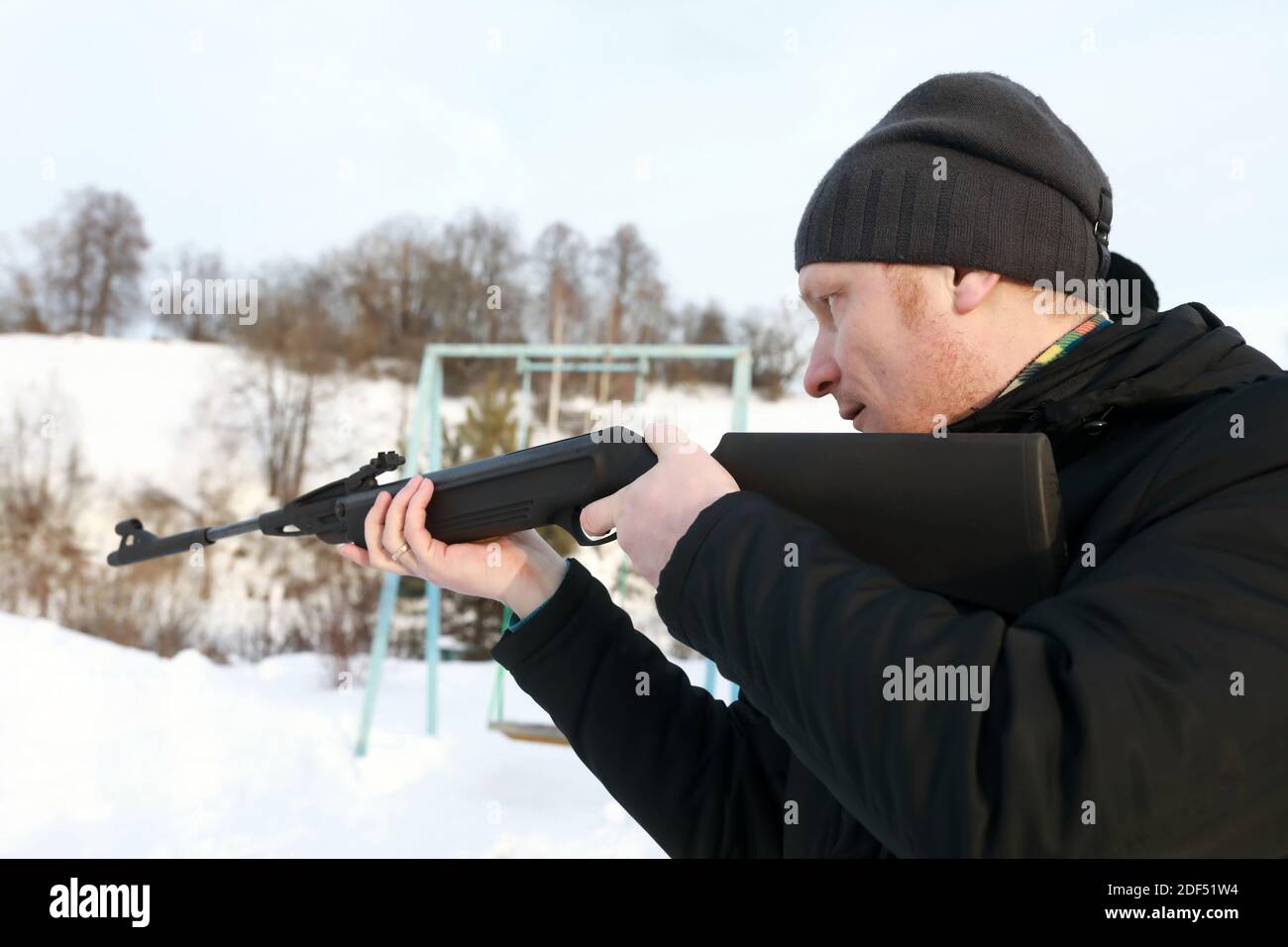 Man aiming with air rifle in winter Stock Photo - Alamy
