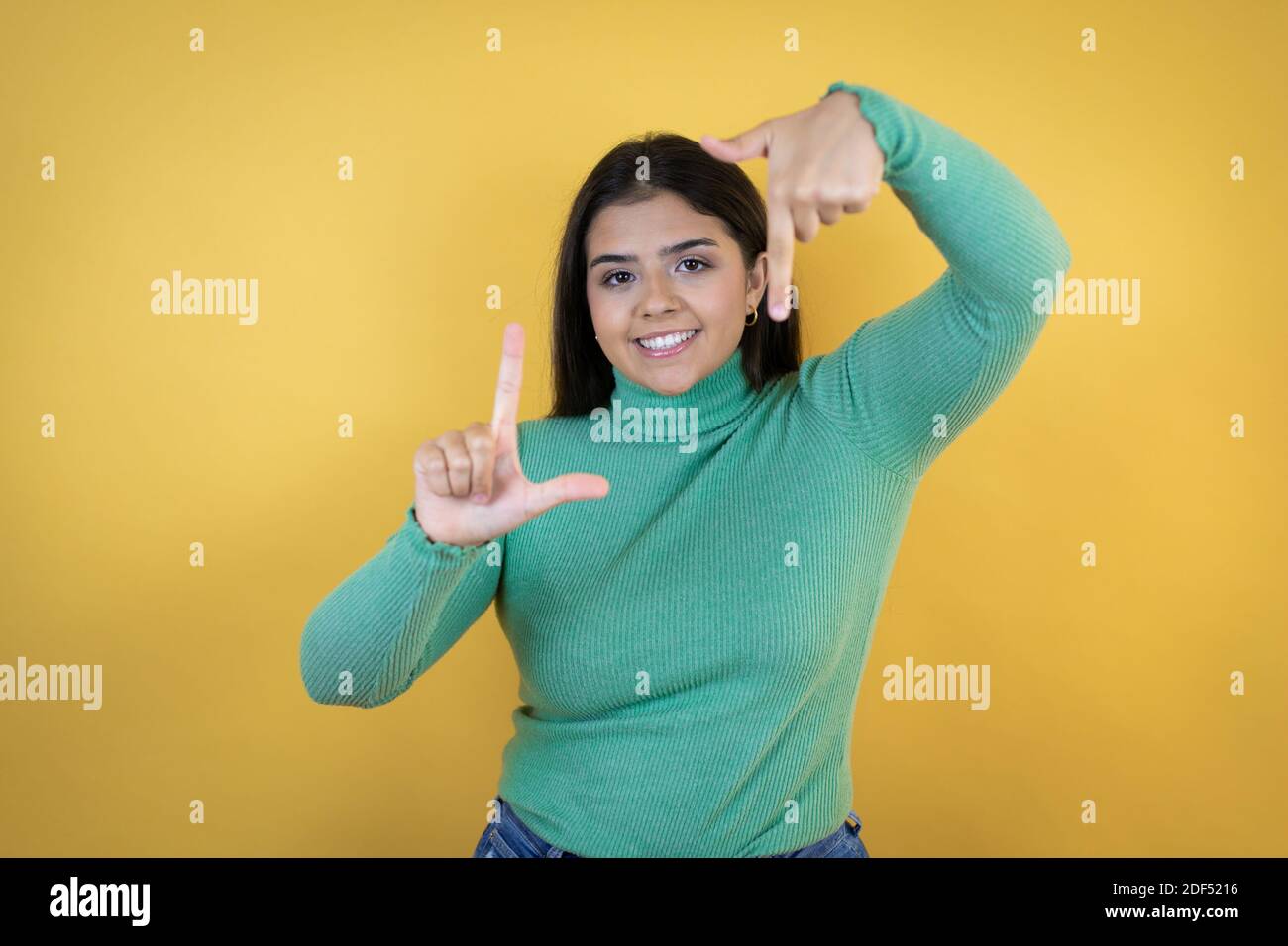Young caucasian woman over isolated yellow background smiling making ...