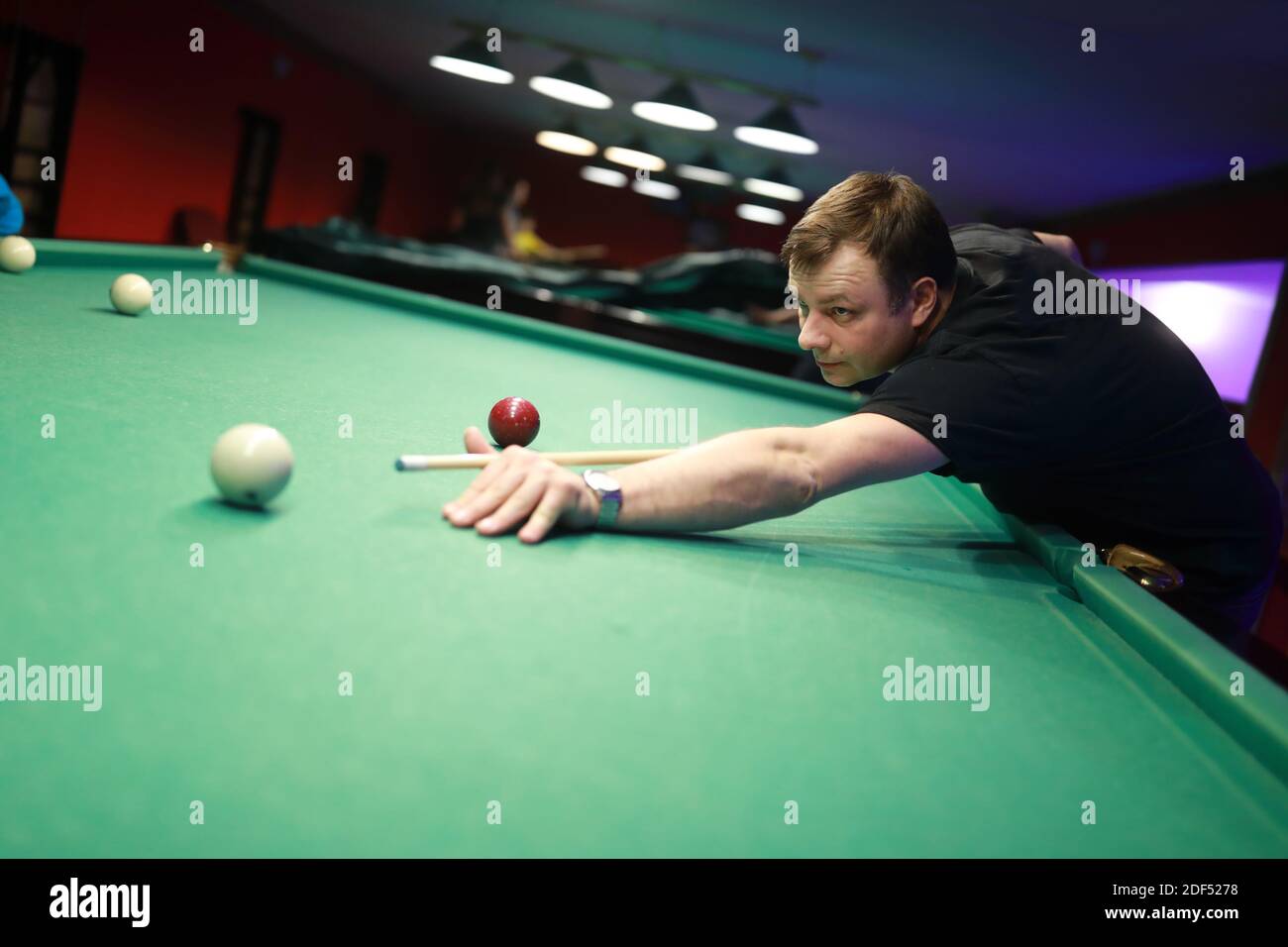 Portrait of serious man hits ball in billiards Stock Photo - Alamy