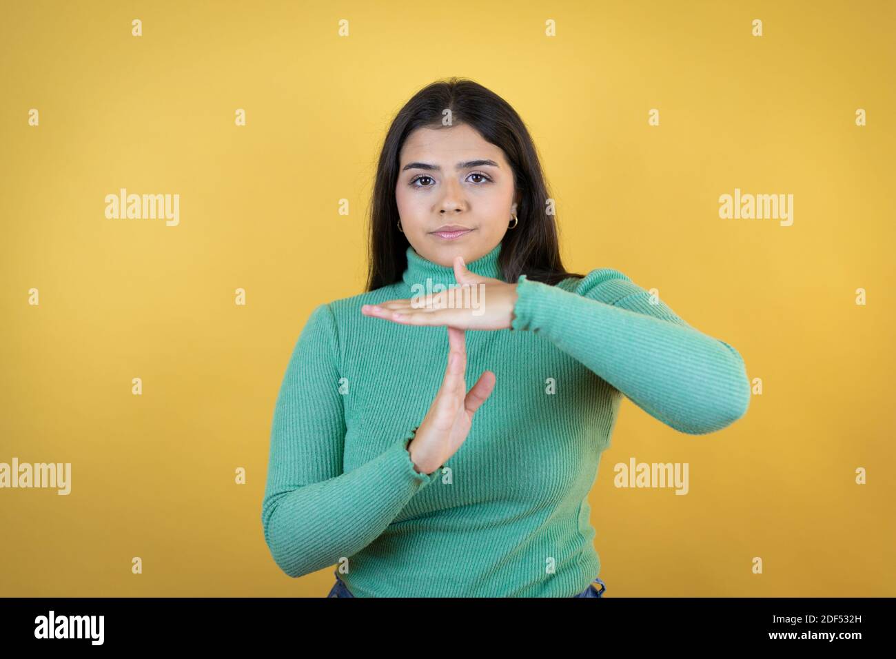 Young caucasian woman over isolated yellow background Doing time out ...