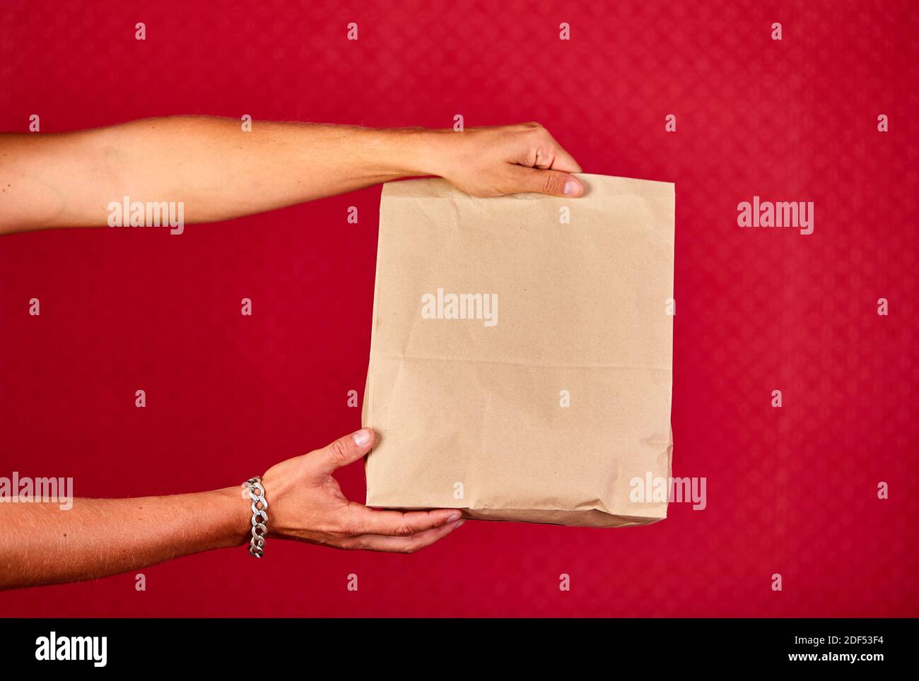 Closeup courier hand holding grocery paper bag, delivery service ...