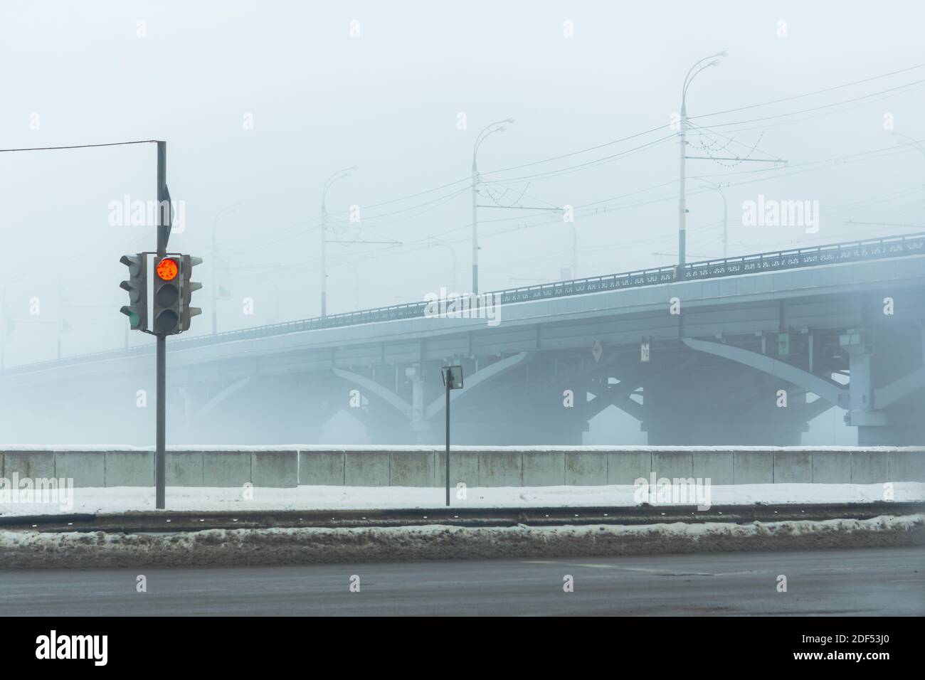 Red traffic light at the intersection in winter city. View of the ...