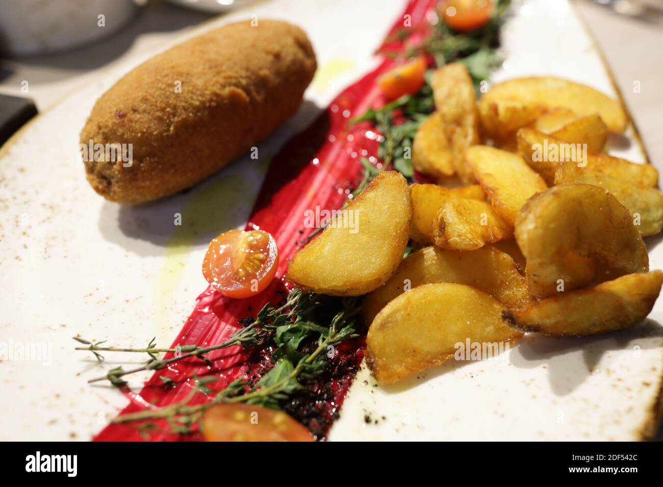 Fried cutlet with potatoes on plate in restaurant Stock Photo - Alamy