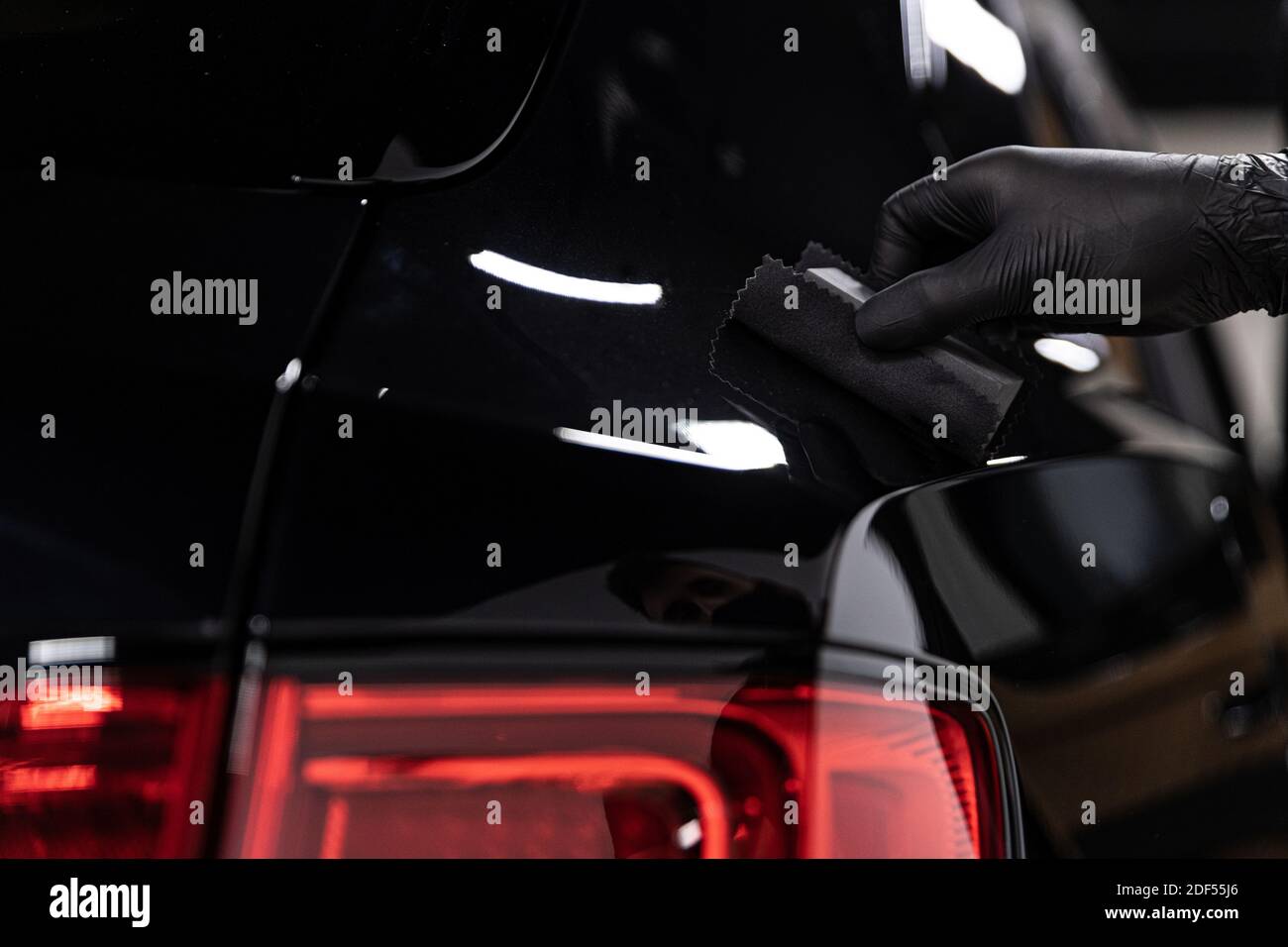 Car detailing studio worker applying ceramic coating Stock Photo - Alamy