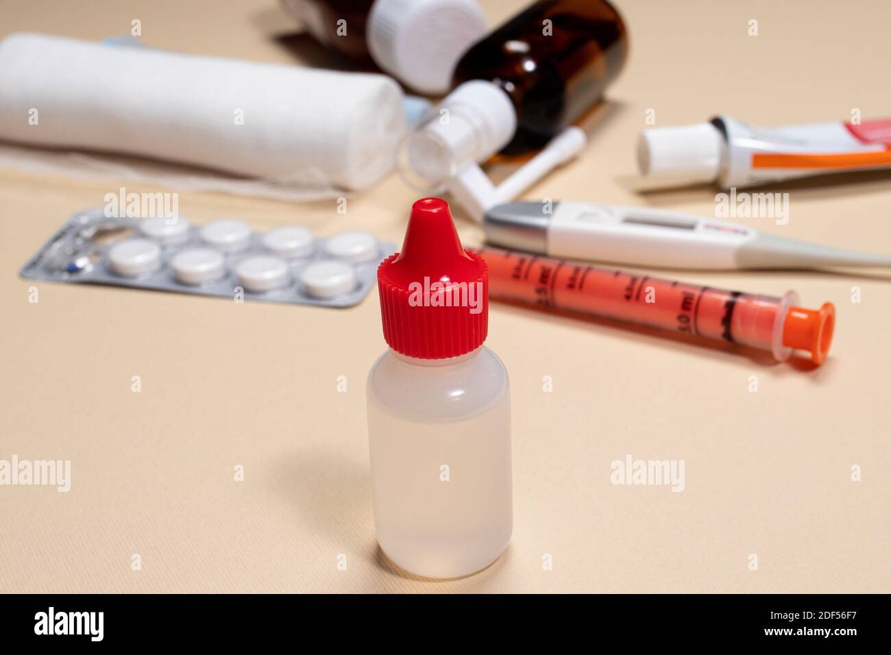 Transparent bottle with a red lid on the background of other cures on a ...