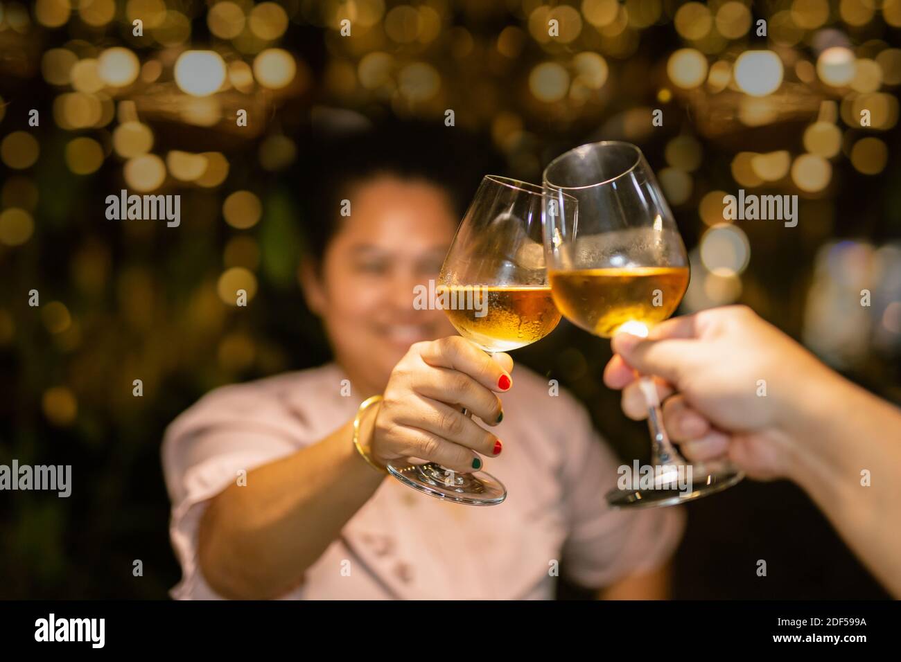 Couple clinking glass of white wine for celebration Stock Photo - Alamy