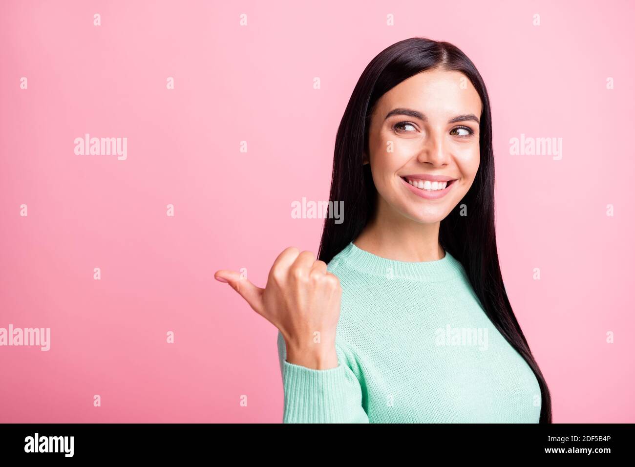 Photo portrait of woman pointing thumb at blank space behind back ...