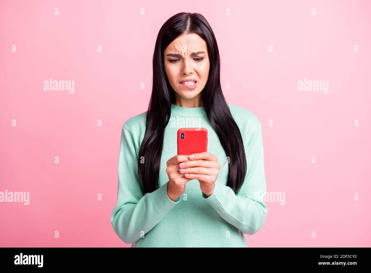 Photo portrait of scared woman biting lower lip holding phone with two ...