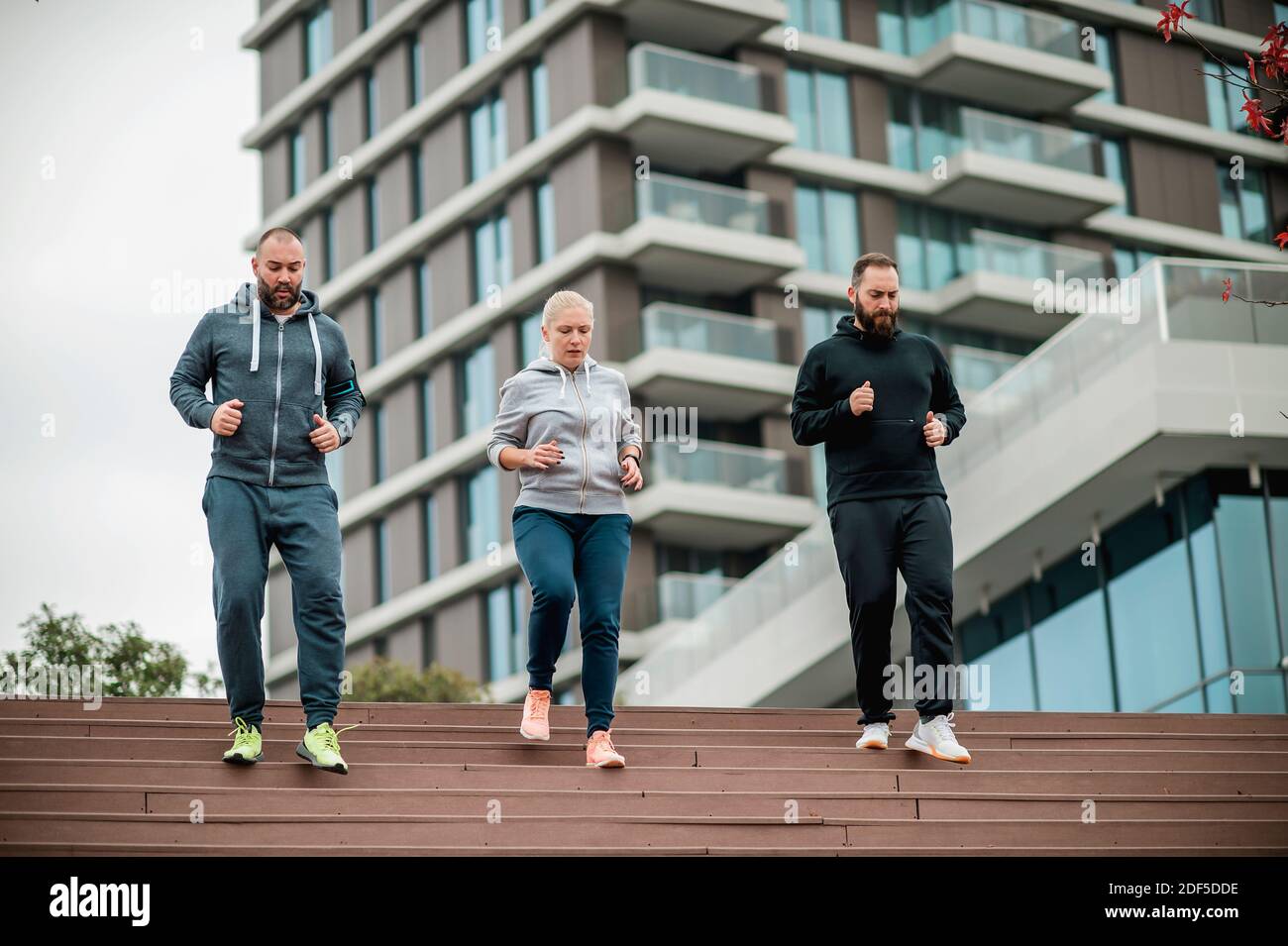 Three young friends running on the steps Stock Photo - Alamy