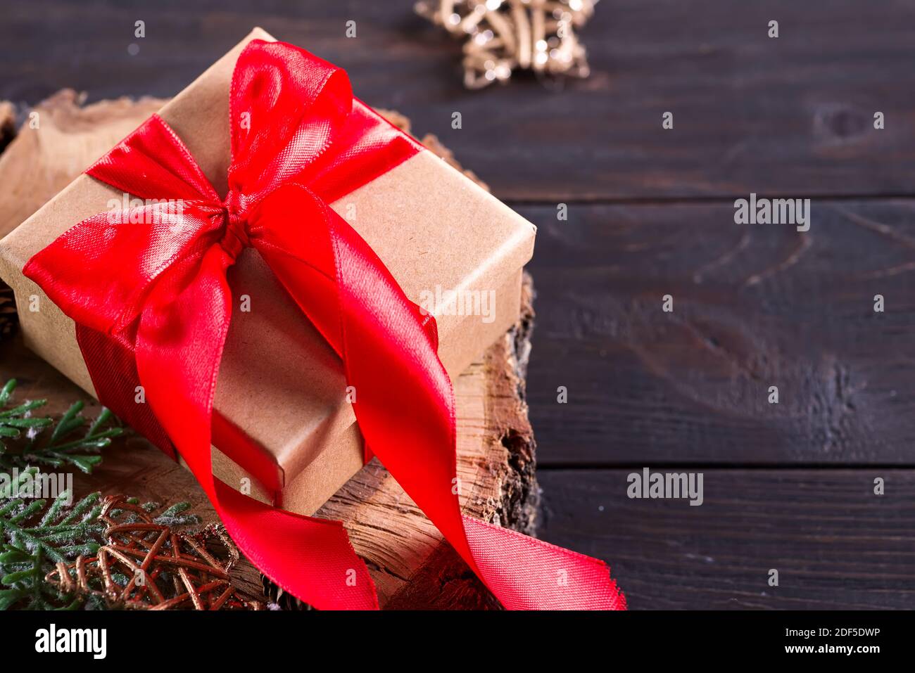 Brown gift box with red bow, christmas decoration on a wood cutting ...