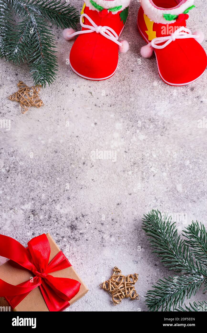 santa claus shoes, fir branches and gift box with red ribbons on a ...