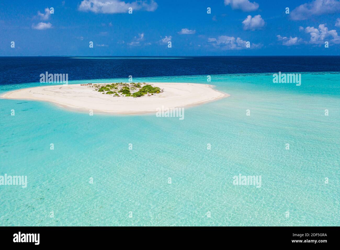 Aerial tropical paradise, small island in shallow blue lagoon. Ocean ...