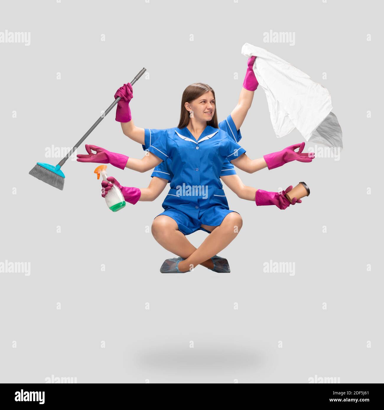 Multitask. Female housemaid in blue uniform and pink gloves like shiva ...