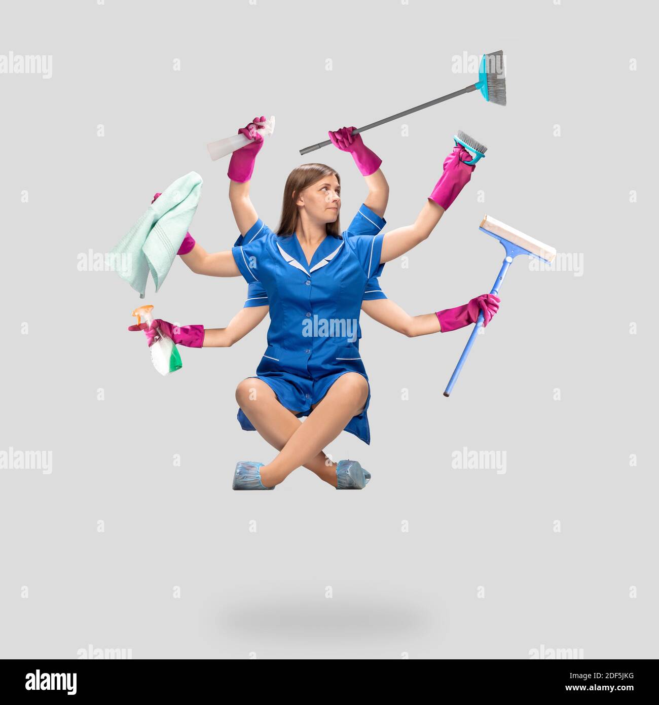 Multitask. Female housemaid in blue uniform and pink gloves like shiva ...
