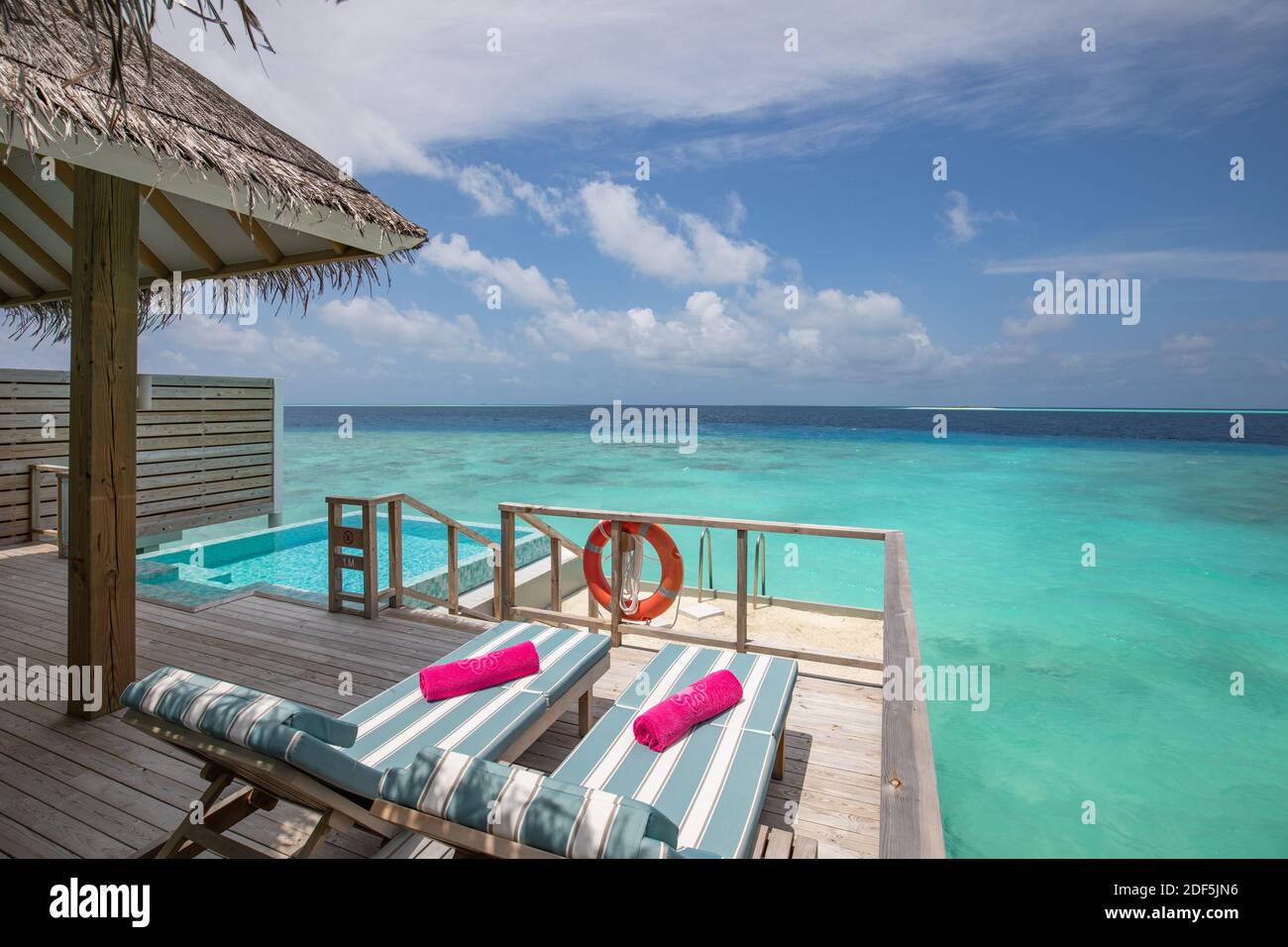 Fantastic over water villa, terrace view with sun beds chairs under ...