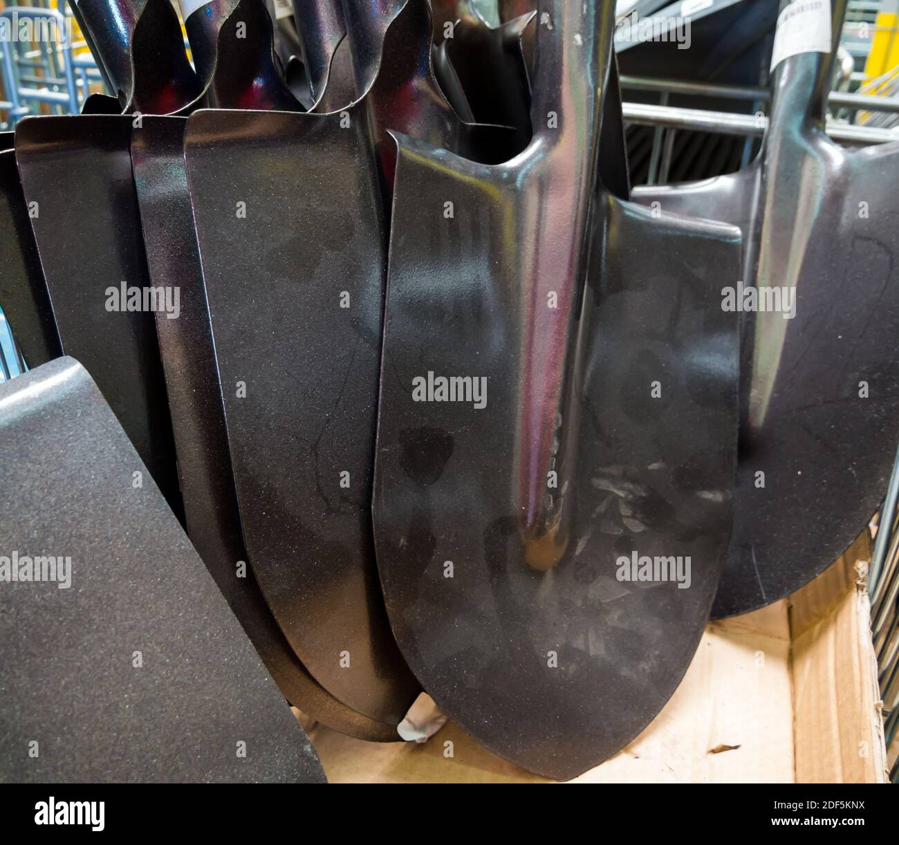 Metal shovel bayonets stacked in container for sale Stock Photo - Alamy