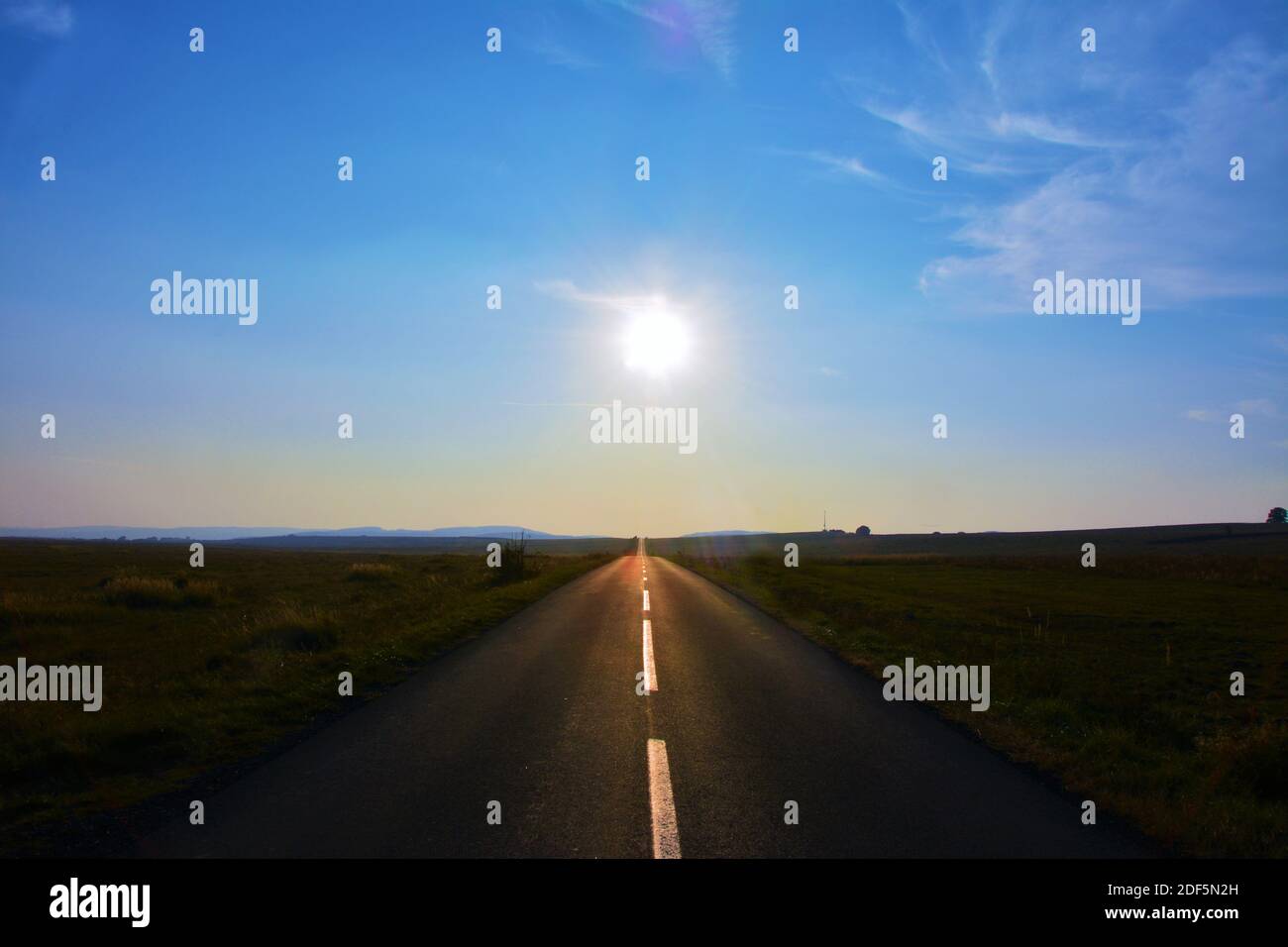 A beautiful scenic view of a straight road with bright sunlight in the ...