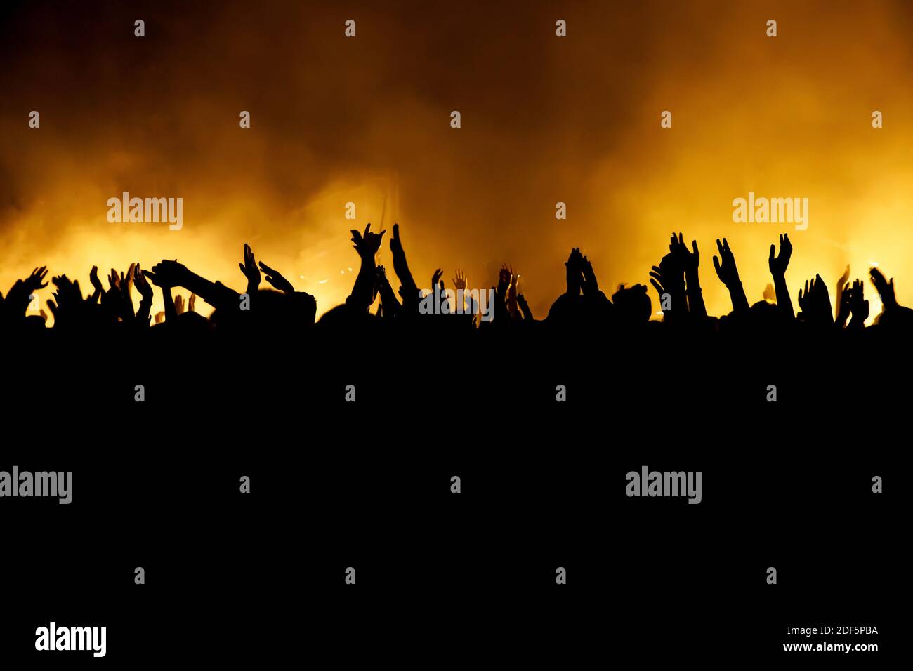 Raised hands in honor of a musical show on stage, People in the hall ...