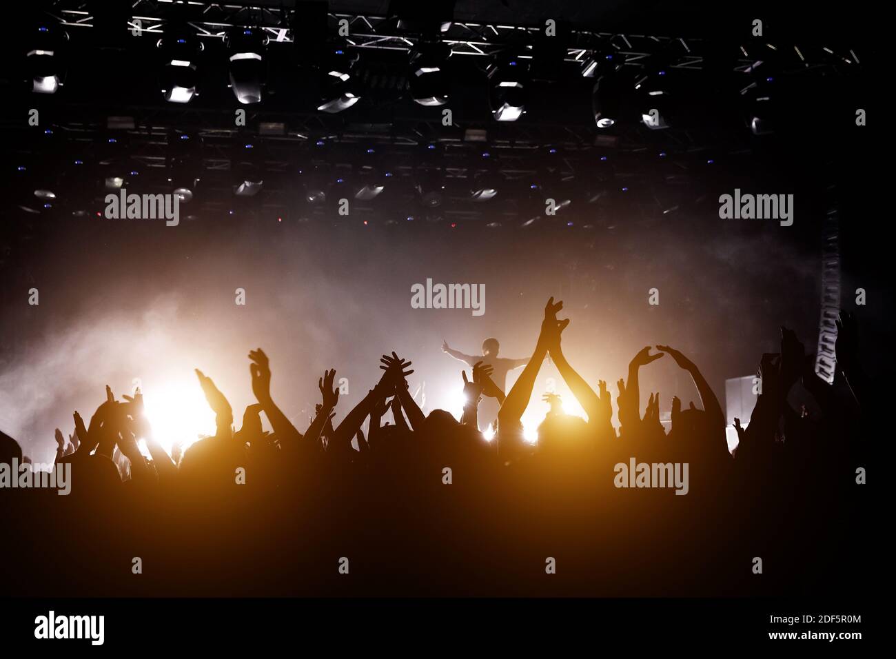 Concert hall with a lit stage and people silhouettes during a concert ...