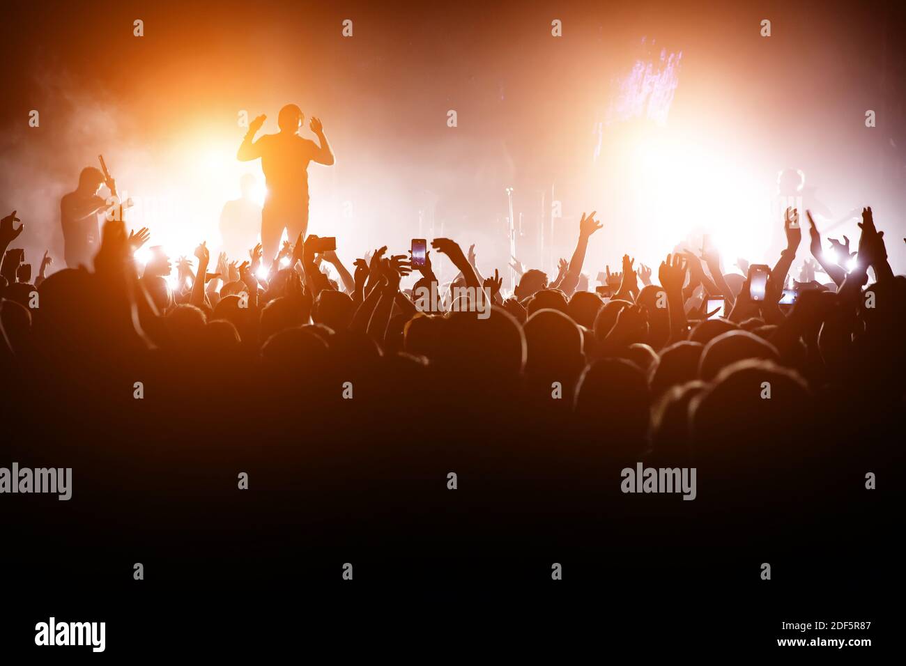 Rock concert. Leader on the stage. Silhouette of the crowd in front of ...