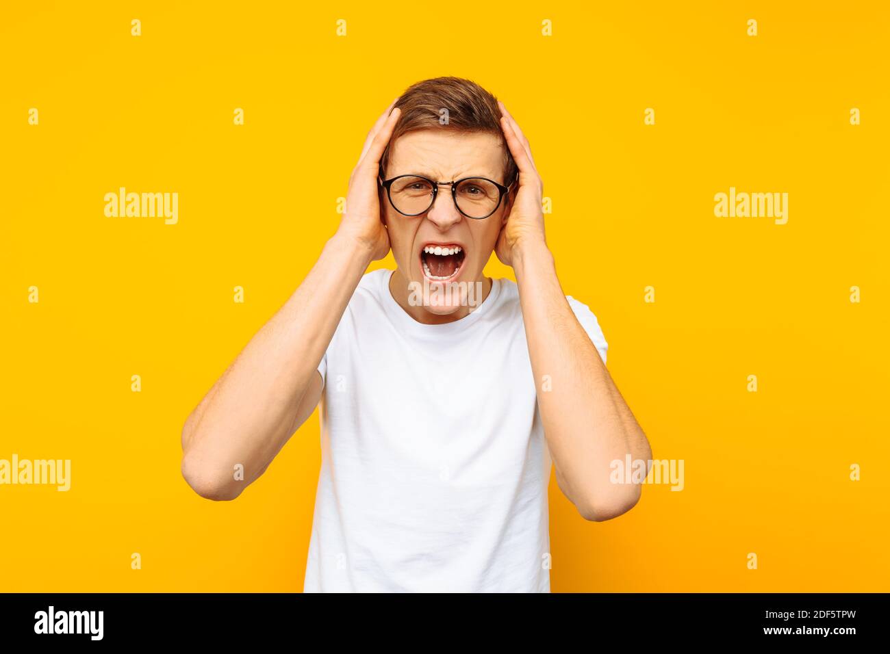 Irritated man with glasses, dressed in a white T-shirt, a man ...