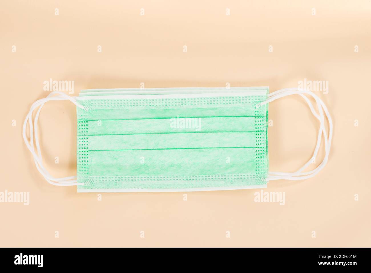 Top view of green surgical face protection mask isolated on beige color ...