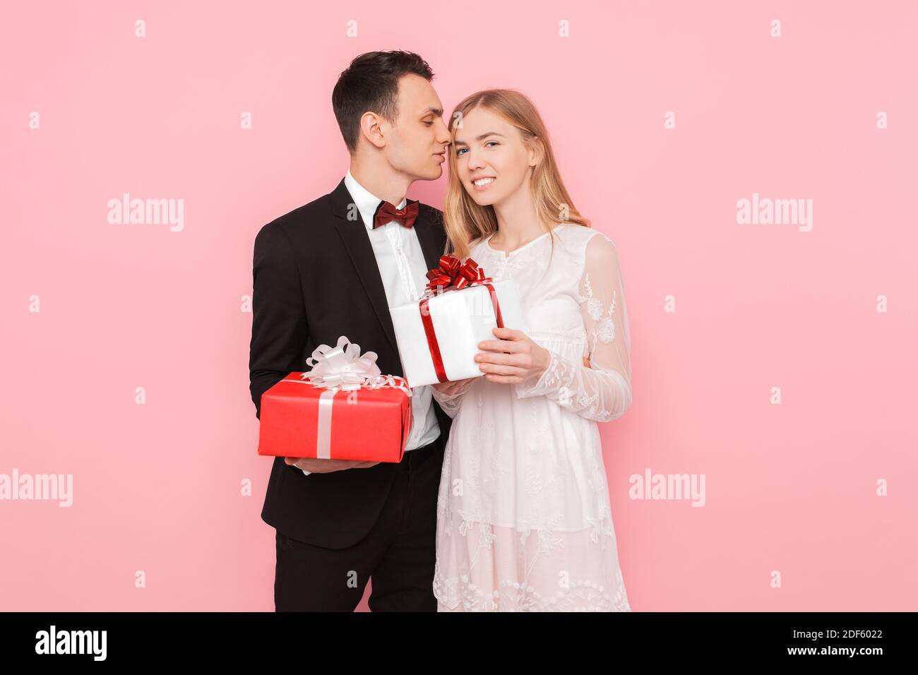 Couple in love, man and woman give each other gifts, on pink background ...