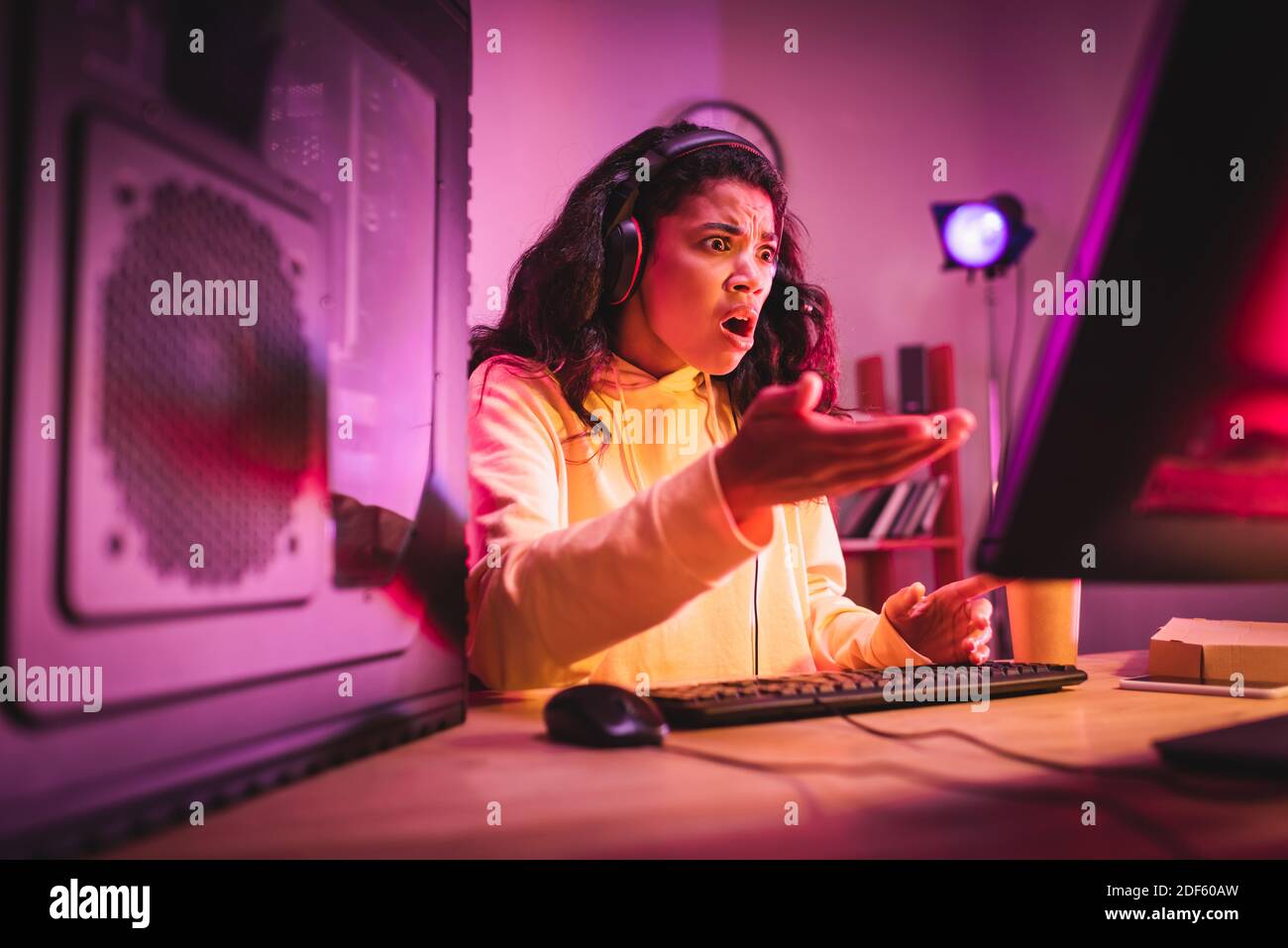 Shocked african american gamer pointing with hand at computer during ...