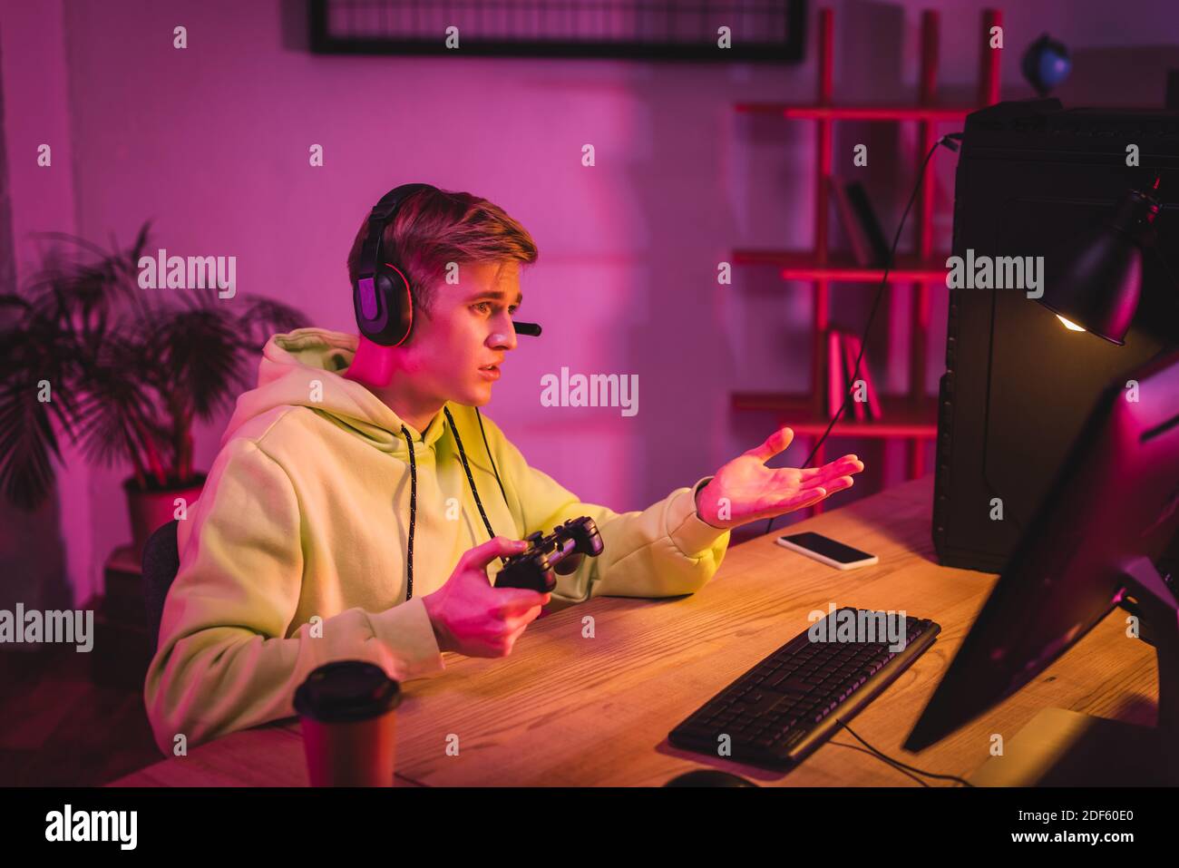 KYIV, UKRAINE - AUGUST 21, 2020: Gamer in headset holding joystick ...