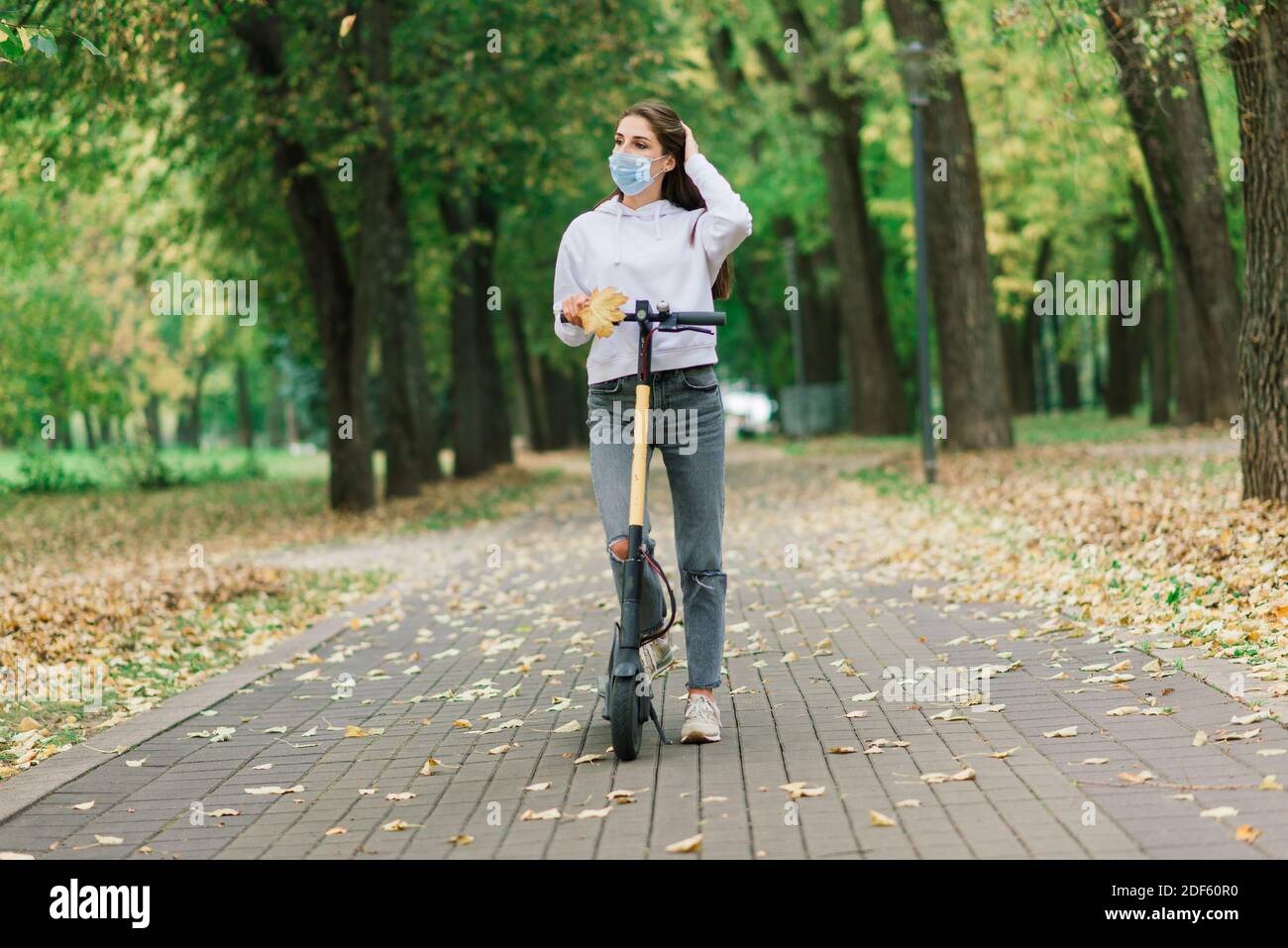 Casual caucasian female wearing protective face mask riding urban ...