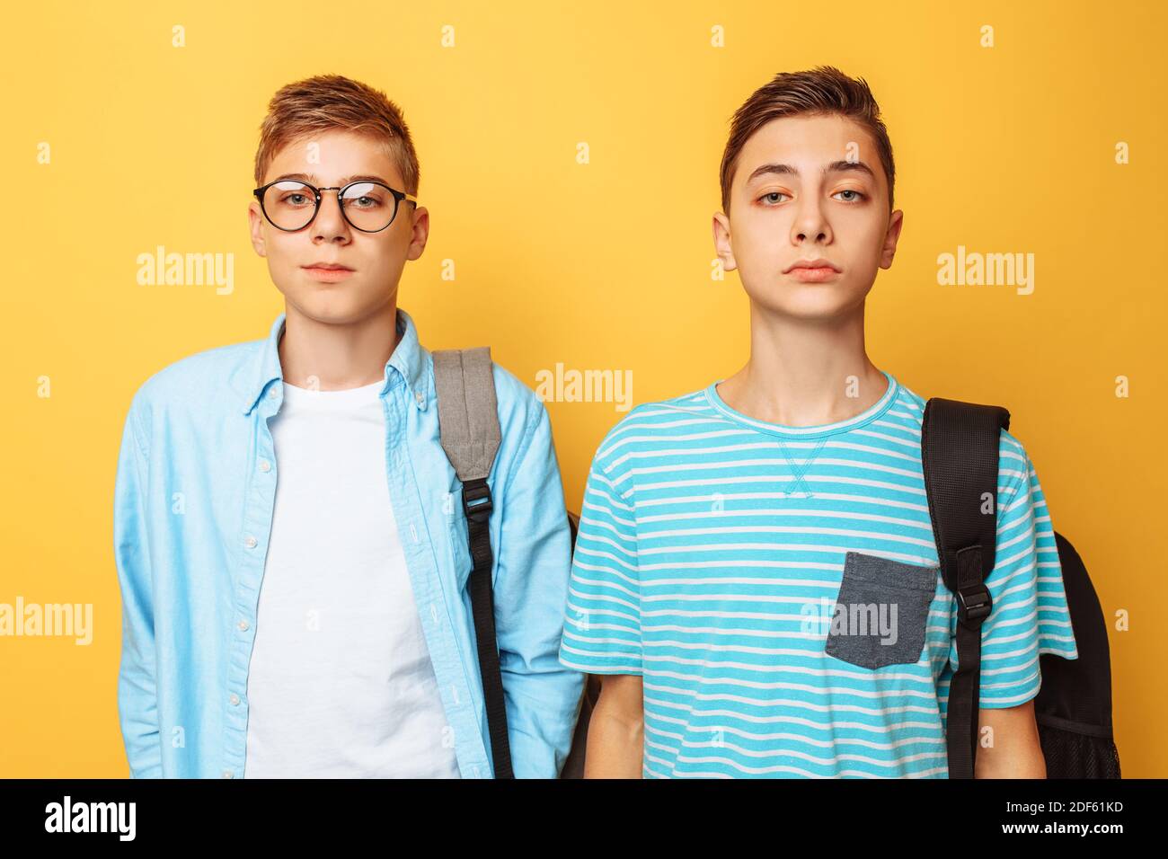 Portrait of two happy stylish guys, friends, isolated on yellow ...