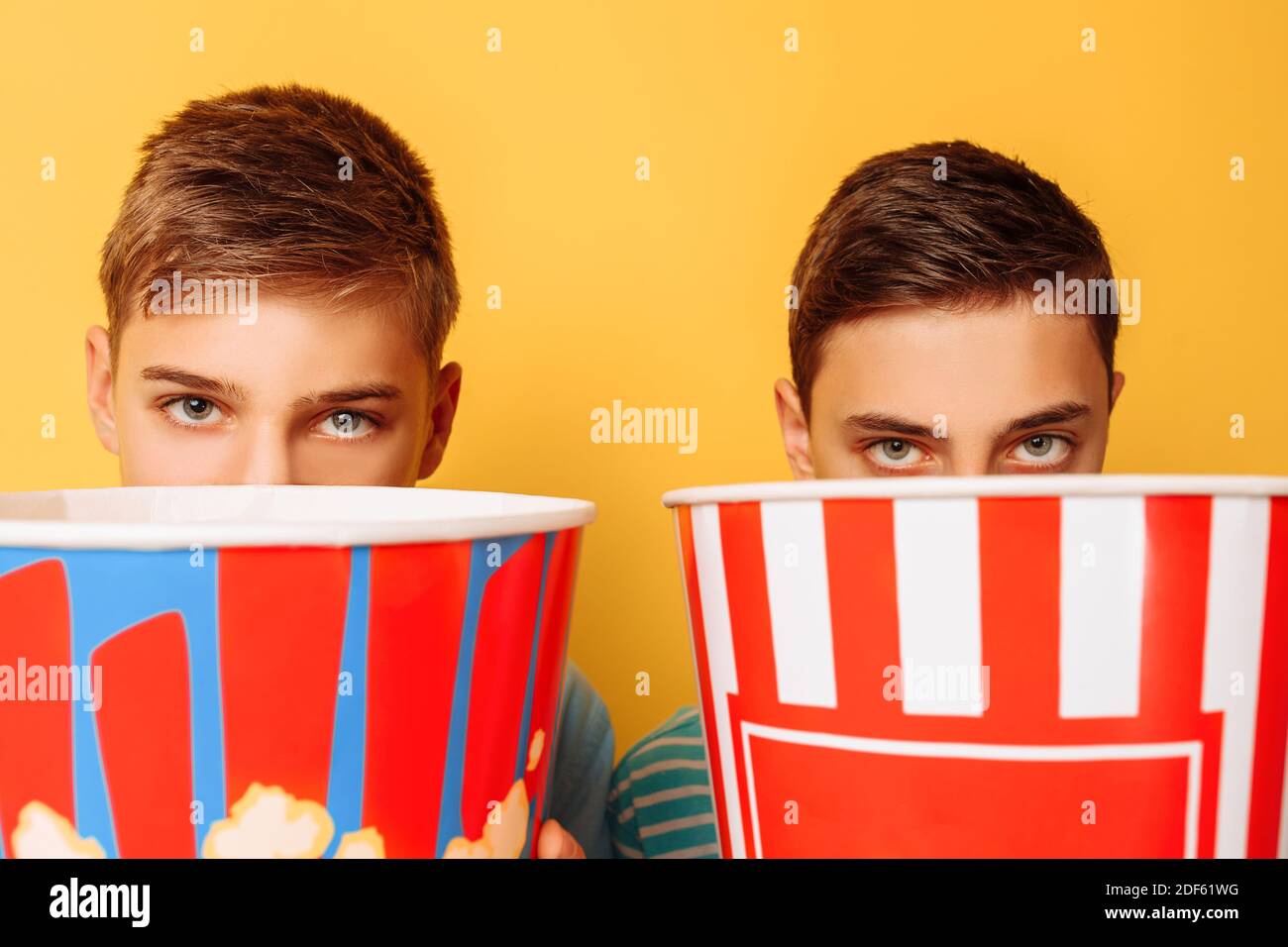 Image of two frightened teenagers, guys watching a horror movie and ...