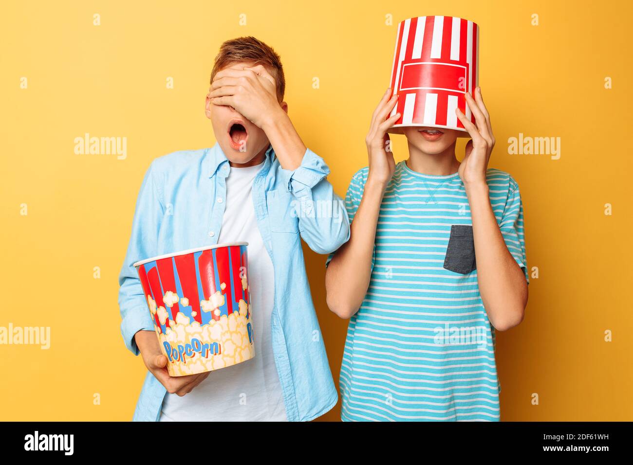Image of two frightened teenagers, guys watching a horror movie and ...