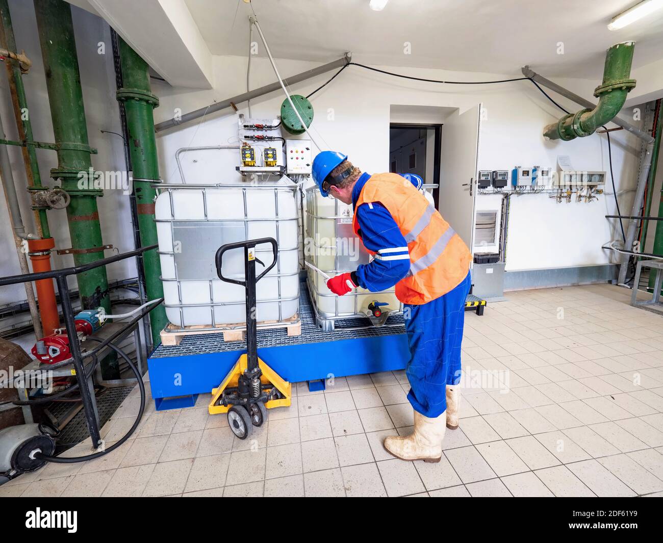 The worker checks the documents on the label of the thousand-liter tank ...